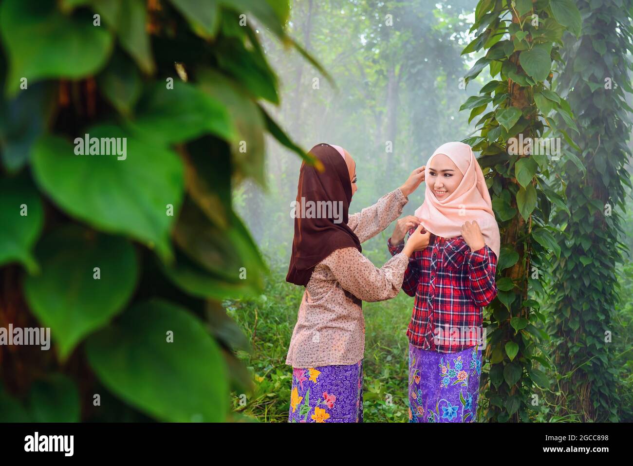 Zwei junge asiatische muslimische Frau im Kopftuch lächeln, Portrait einer attraktiven jungen ...