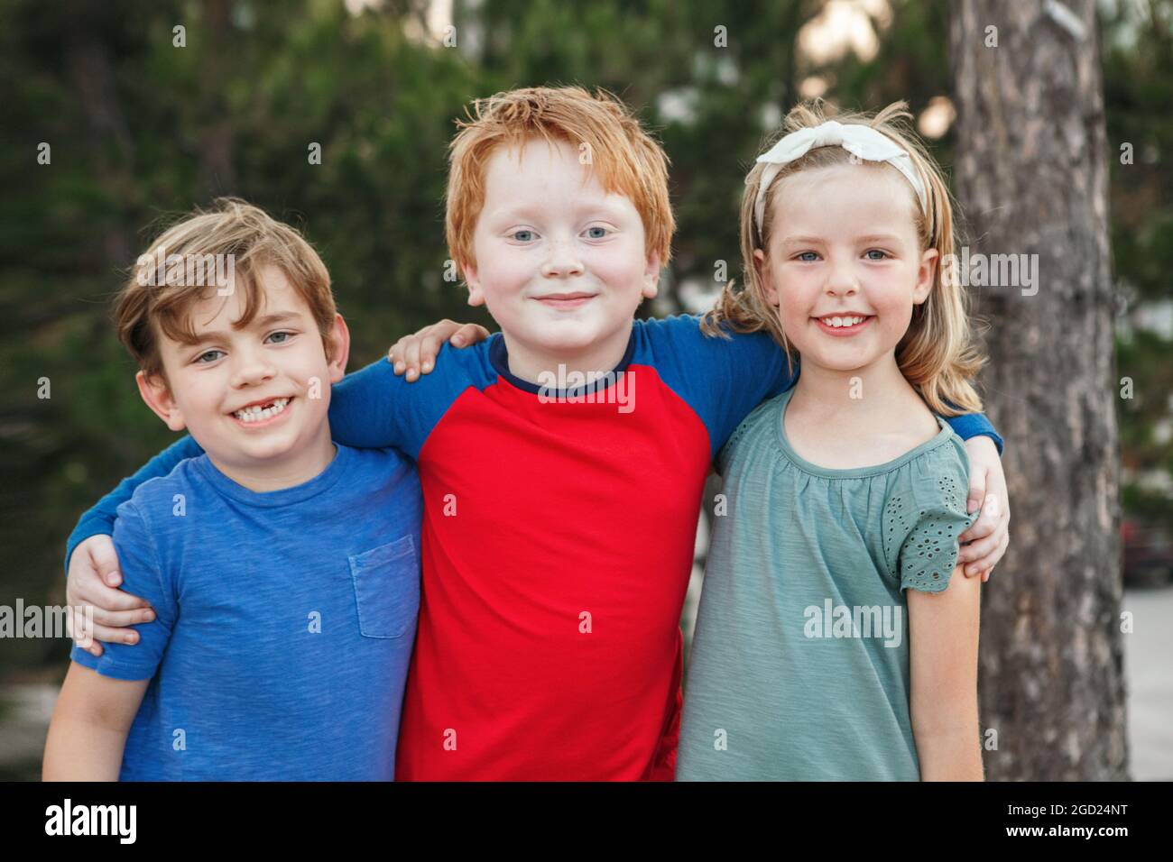 Drei glückliche kaukasische kleine Kinder, Jungen und Mädchen, die sich ...