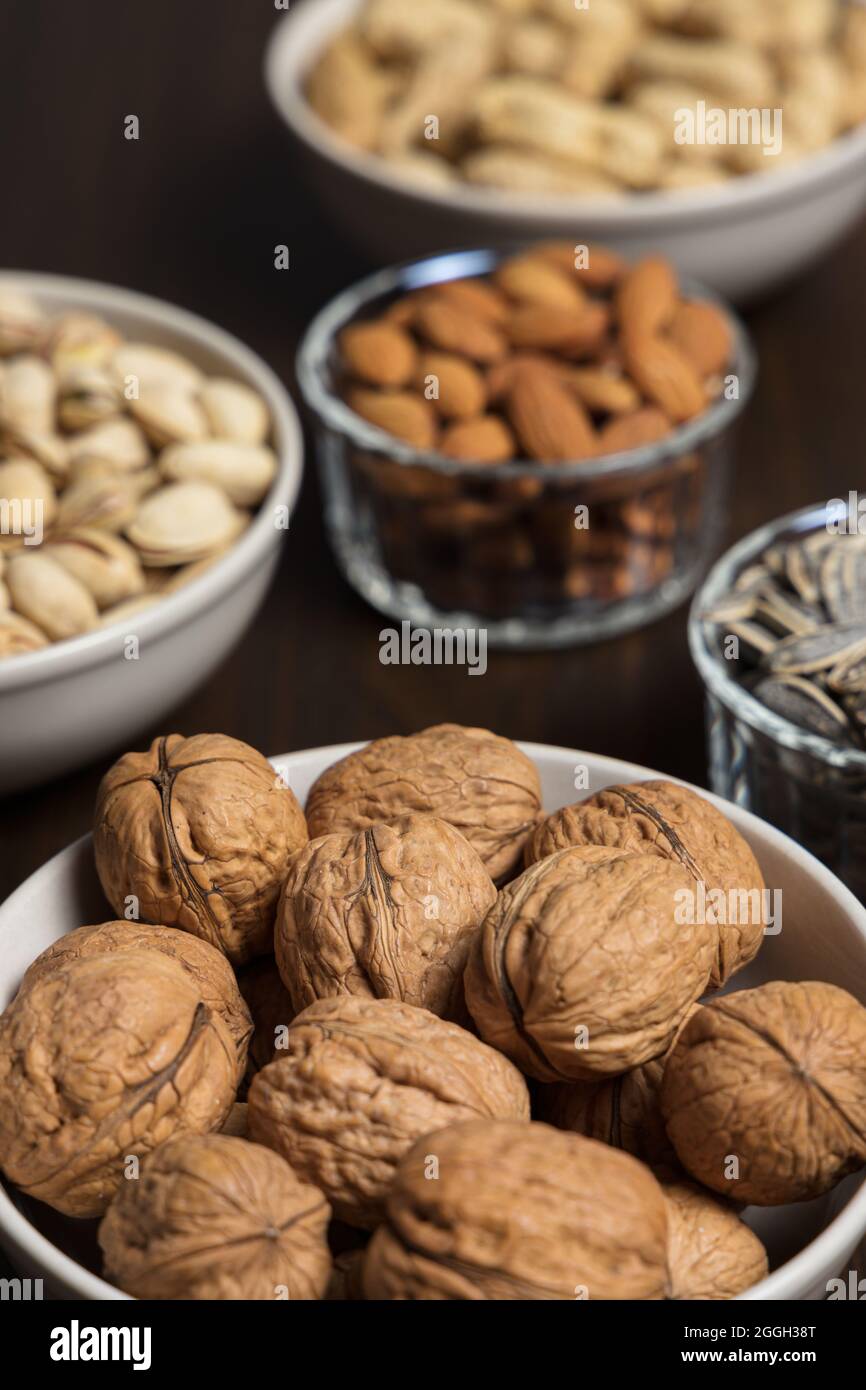 Sortiment von Nüssen in verschiedenen Schalen: Mandel-, Walnuss ...
