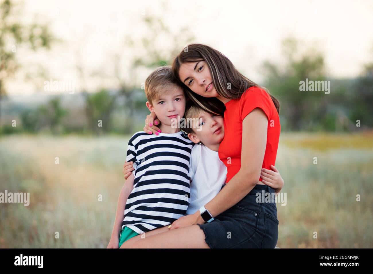 Ehrliches, authentisches Familienportrait. Zwanglose Mutter mit zwei Söhnen in vertraulicher ...