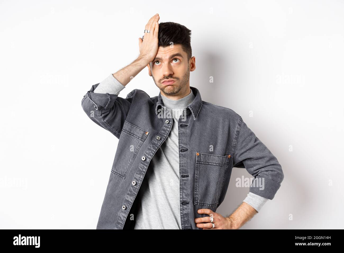 Verärgerter junger Mann, der müde oder belästigt aussieht, die Augen ...
