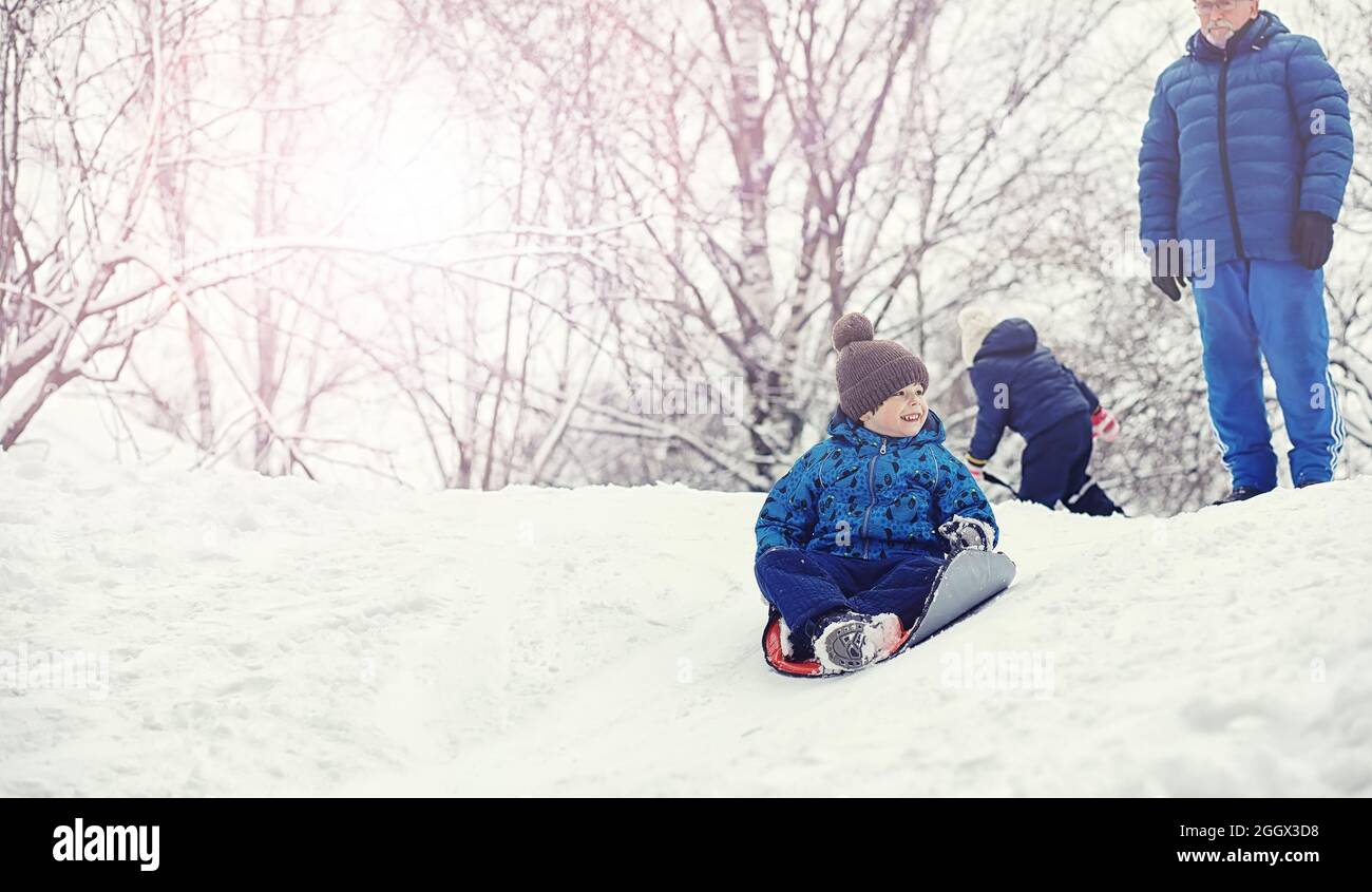 Kinder im Park im Winter. Kinder spielen mit Schnee auf dem Spielplatz ...