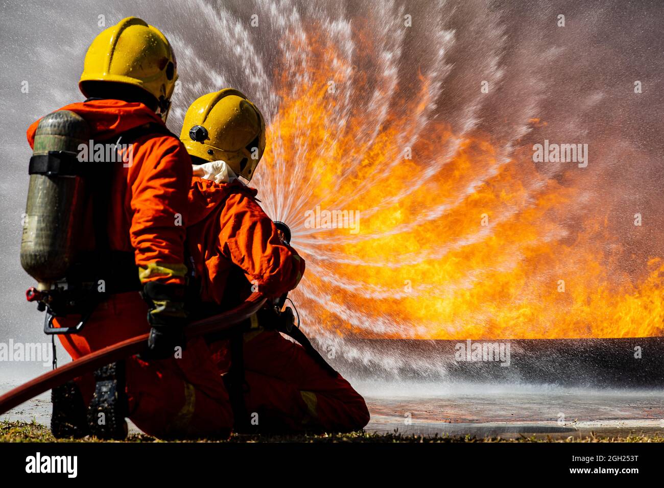 Team von zwei Feuerwehrleuten tragen volle Uniform mit Sauerstoff-Tank ...