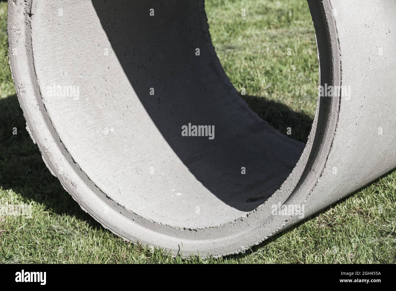 Gut Konstruktionsdetails. Ein grauer Betonring liegt auf grünem Gras ...