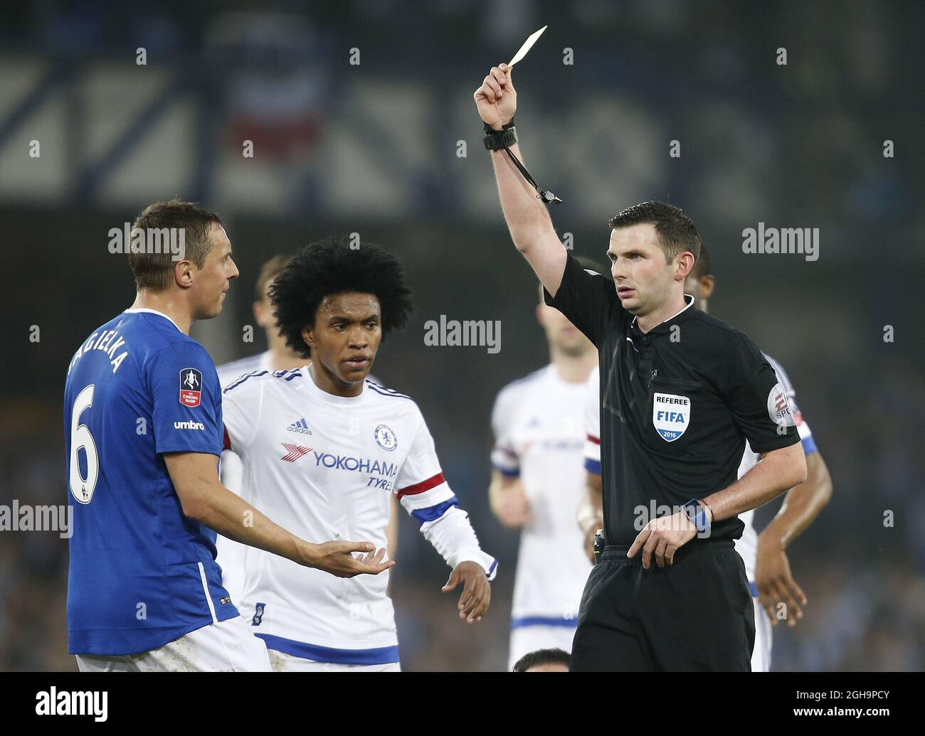 Schiedsrichter Michael Oliver zeigt Phil Jagielka von Everton während ...