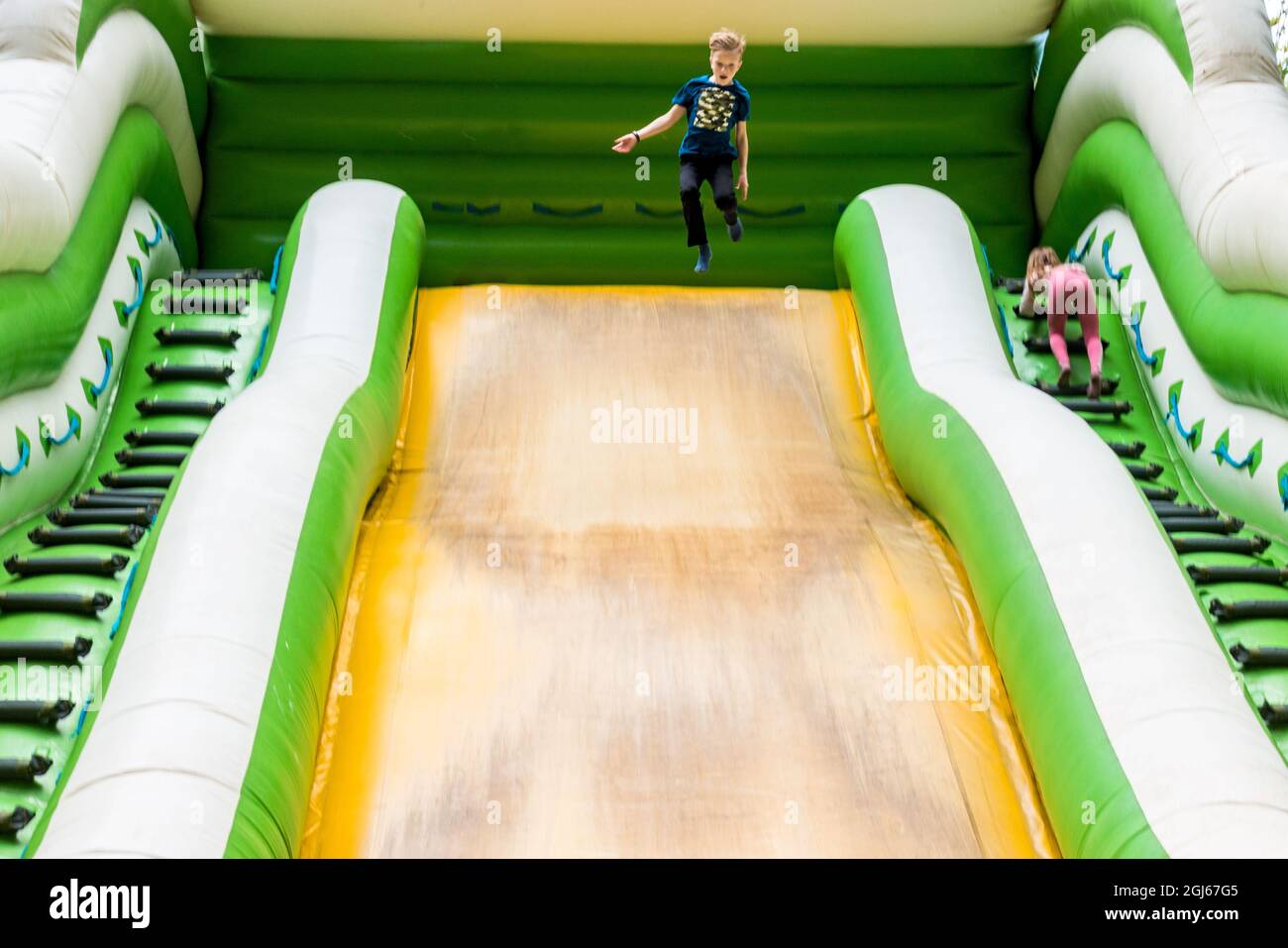 Der Junge springt von einer aufblasbaren Rutsche Stockfotografie - Alamy
