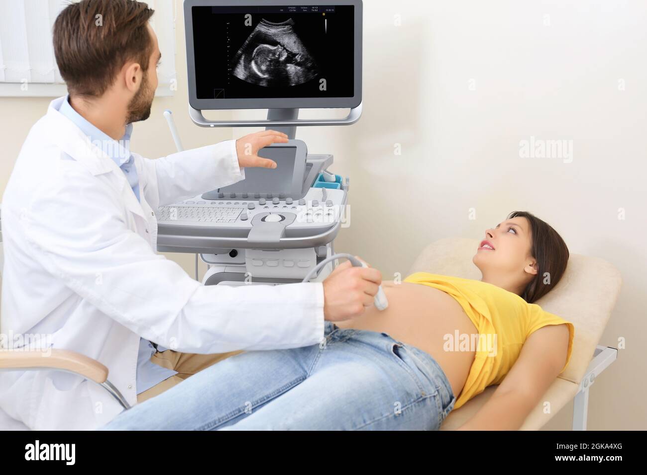 Junge schwangere Frau, die sich einer Ultraschall in Klinik Scan ...