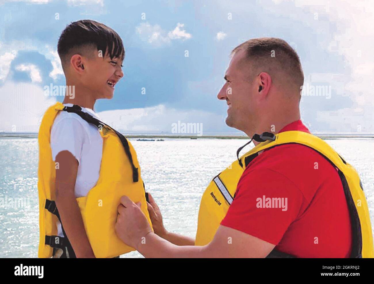 Ein Vater zieht seinem Sohn eine Schwimmweste an. Von der MCIPAC ...