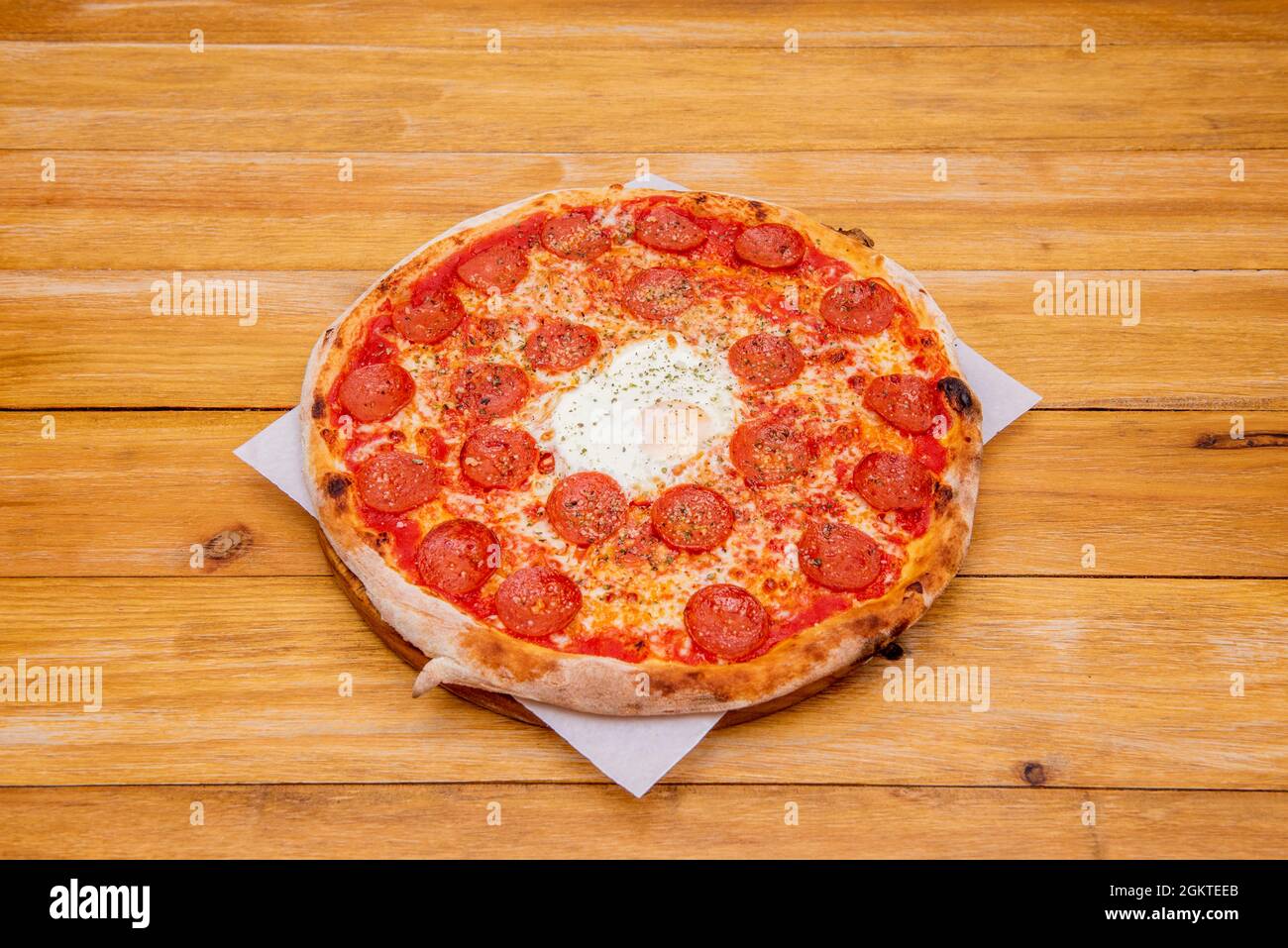 Große Menge Pepperoni Pizza mit einem Spiegelei in der Mitte und ...