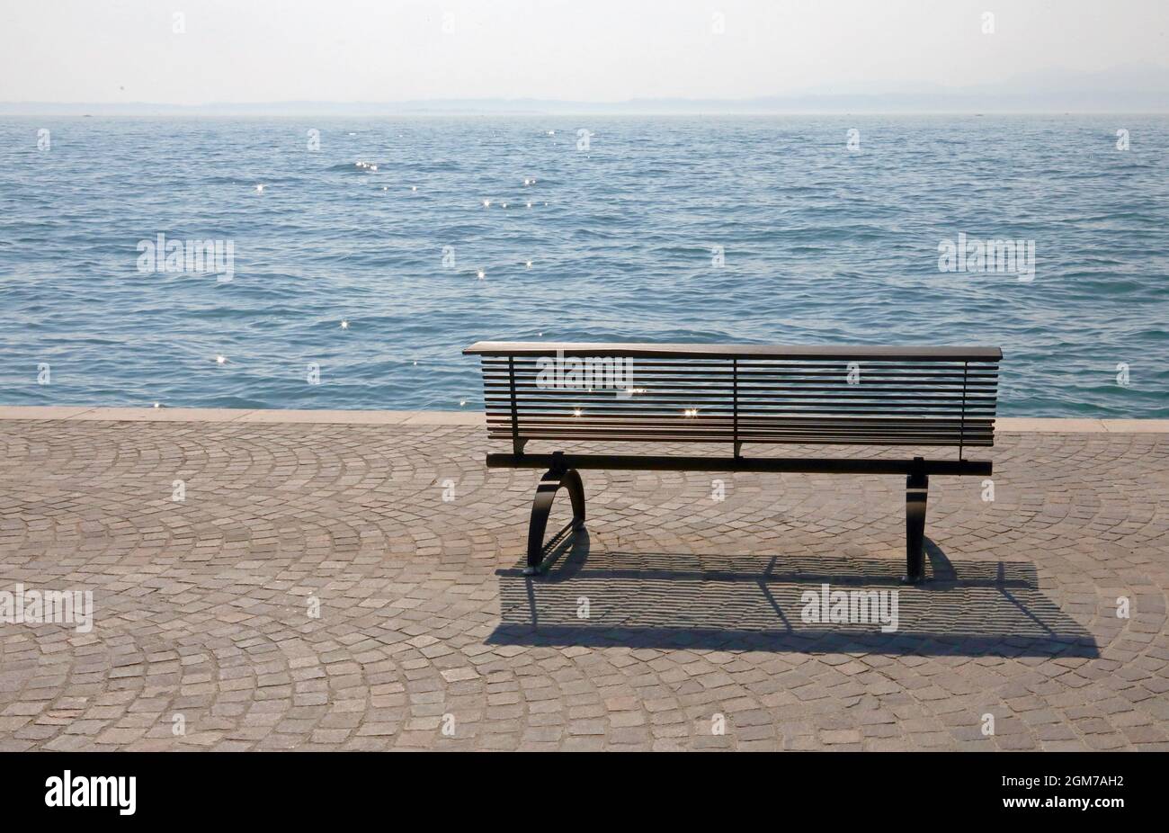 Einsame Bank am Ufer mit dem ruhigen Wasser Symbol der Ruhe ...
