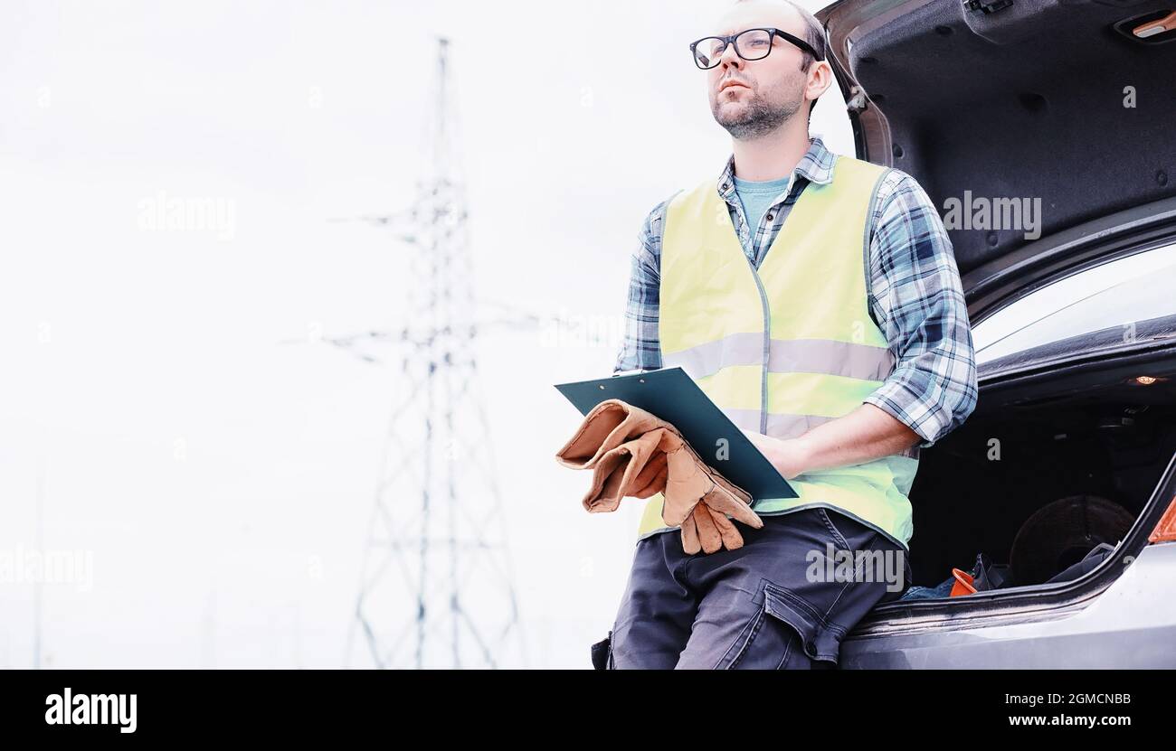Ein Mann in Helm und Uniform, ein Elektriker auf dem Feld. Ein ...