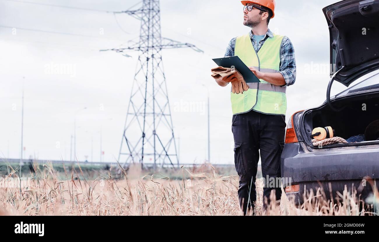 Ein Mann in Helm und Uniform, ein Elektriker auf dem Feld. Ein ...