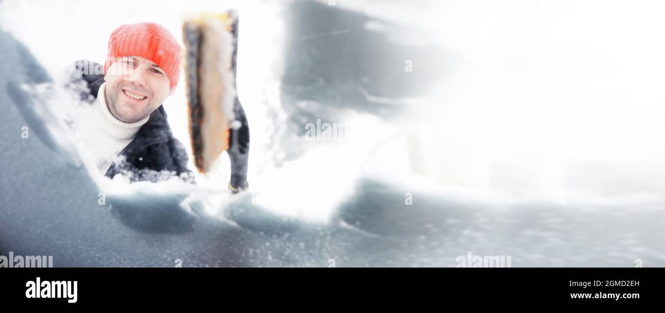 Ein männlicher Fahrer steht vor einem Auto. Der Besitzer reinigt das ...