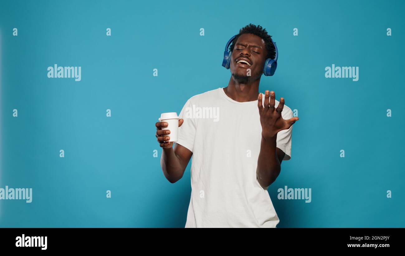 afroamerikanischer Mann, der Kopfhörer benutzt, um im Studio Musik zu ...