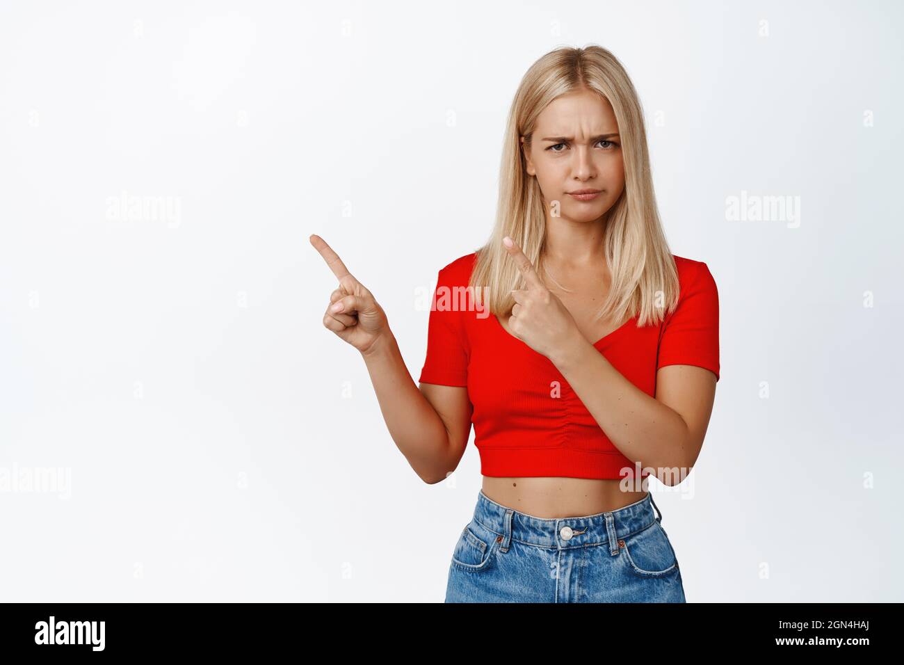 Wütend schmollende Freundin zeigt die Finger auf die obere linke Ecke ... Wütend schmollende Freundin zeigt die Finger auf die obere linke Ecke ...