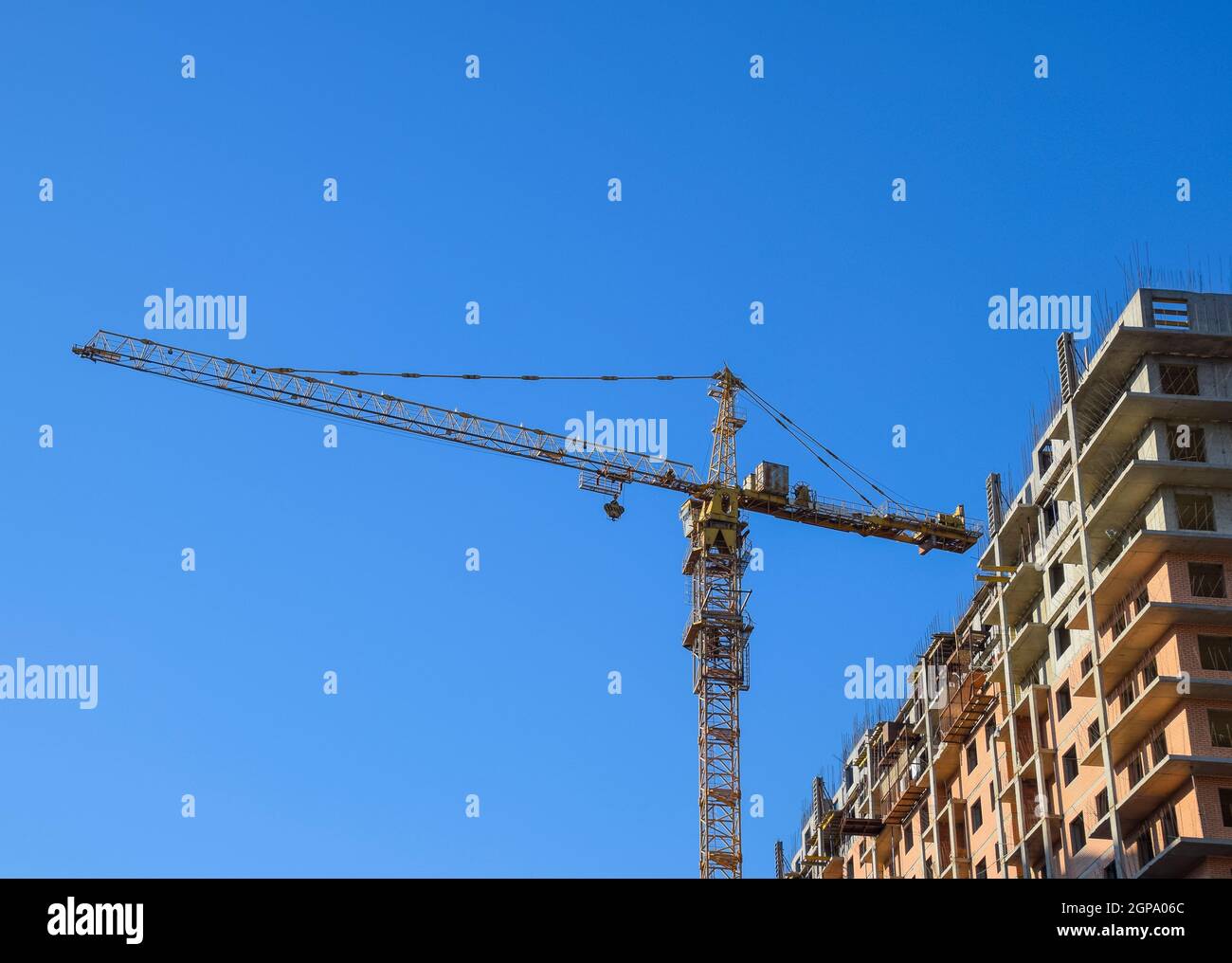 Bau eines neuen Hauses. Turm Gebäude Kran gegen den blauen Himmel und ...