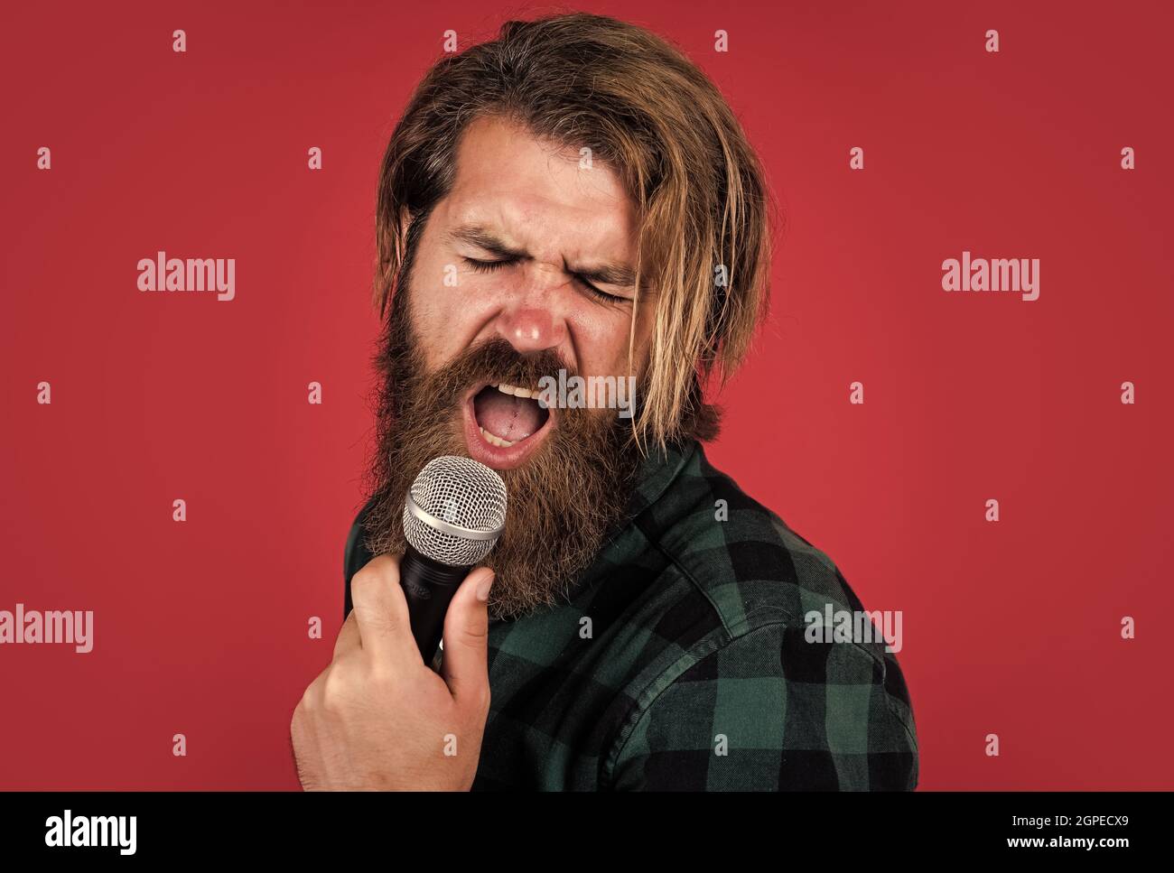 Bärtiger Mann mit kariertem Hemd. Rockmusik. Männlicher Karaoke-Sänger ...