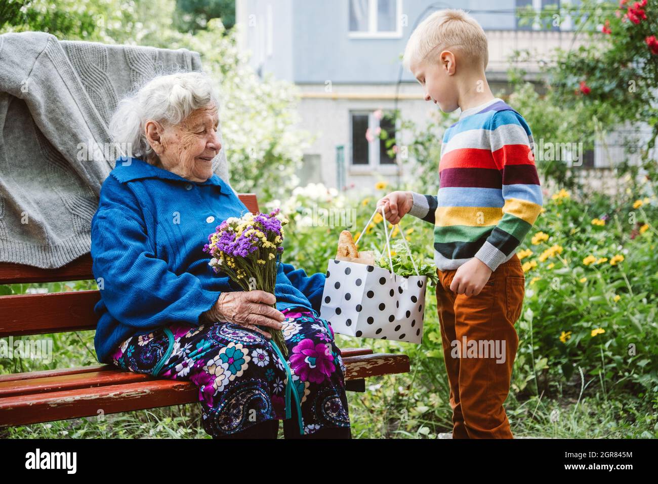 90-jährige Urgroßmutter, Großmutter mit Enkel zusammen. Enkel Hugs ...