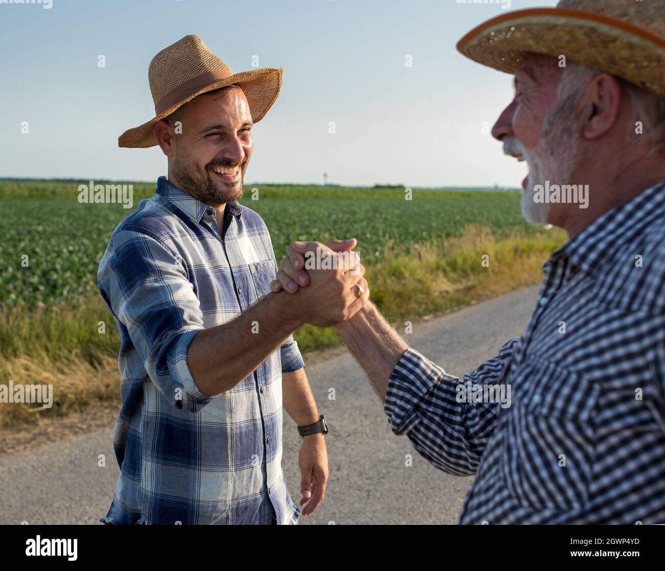 Älterer Bauer schüttelt sich die Hände mit einem jungen Mann im ...