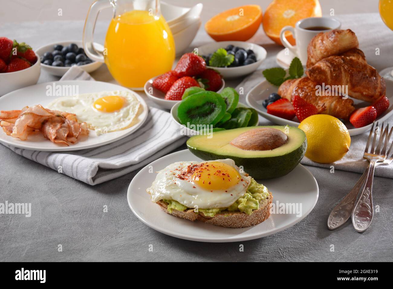Gesundes Frühstück. Toast mit Avocado und Ei, Speck und Eier, frisches ...