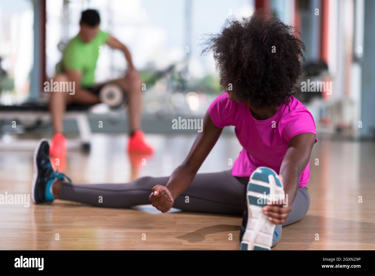 glückliche junge afroamerikanische Frau in einem Fitnessstudio, dehnen ... glückliche junge afroamerikanische Frau in einem Fitnessstudio, dehnen ...