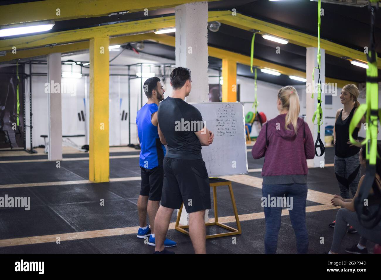 Ausbildung. Gruppe von jungen Athleten erhalten Anweisungen vom Trainer ...