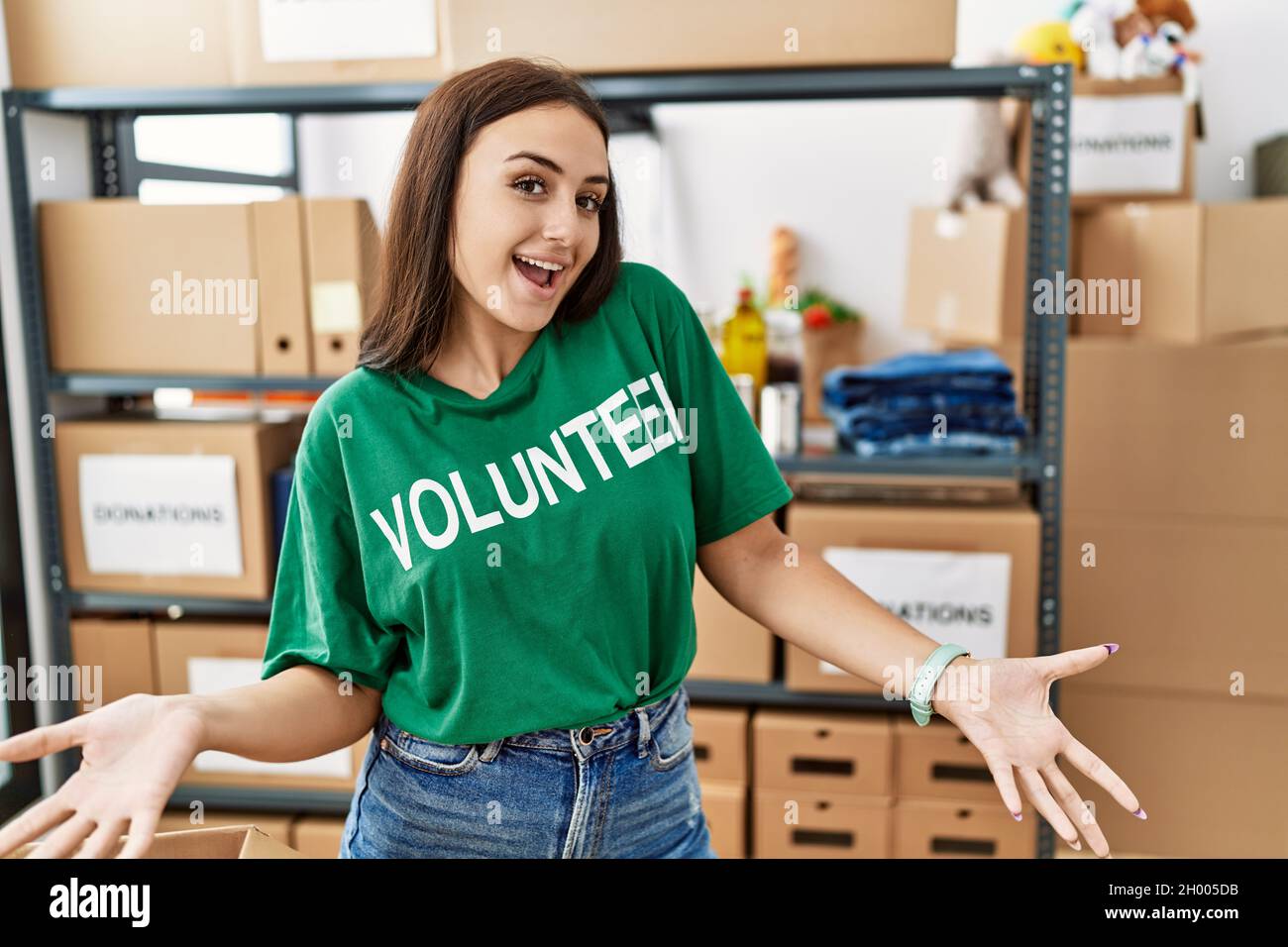 Junge Brünette Frau trägt Freiwilligen T-Shirt bei Spenden stehen ...