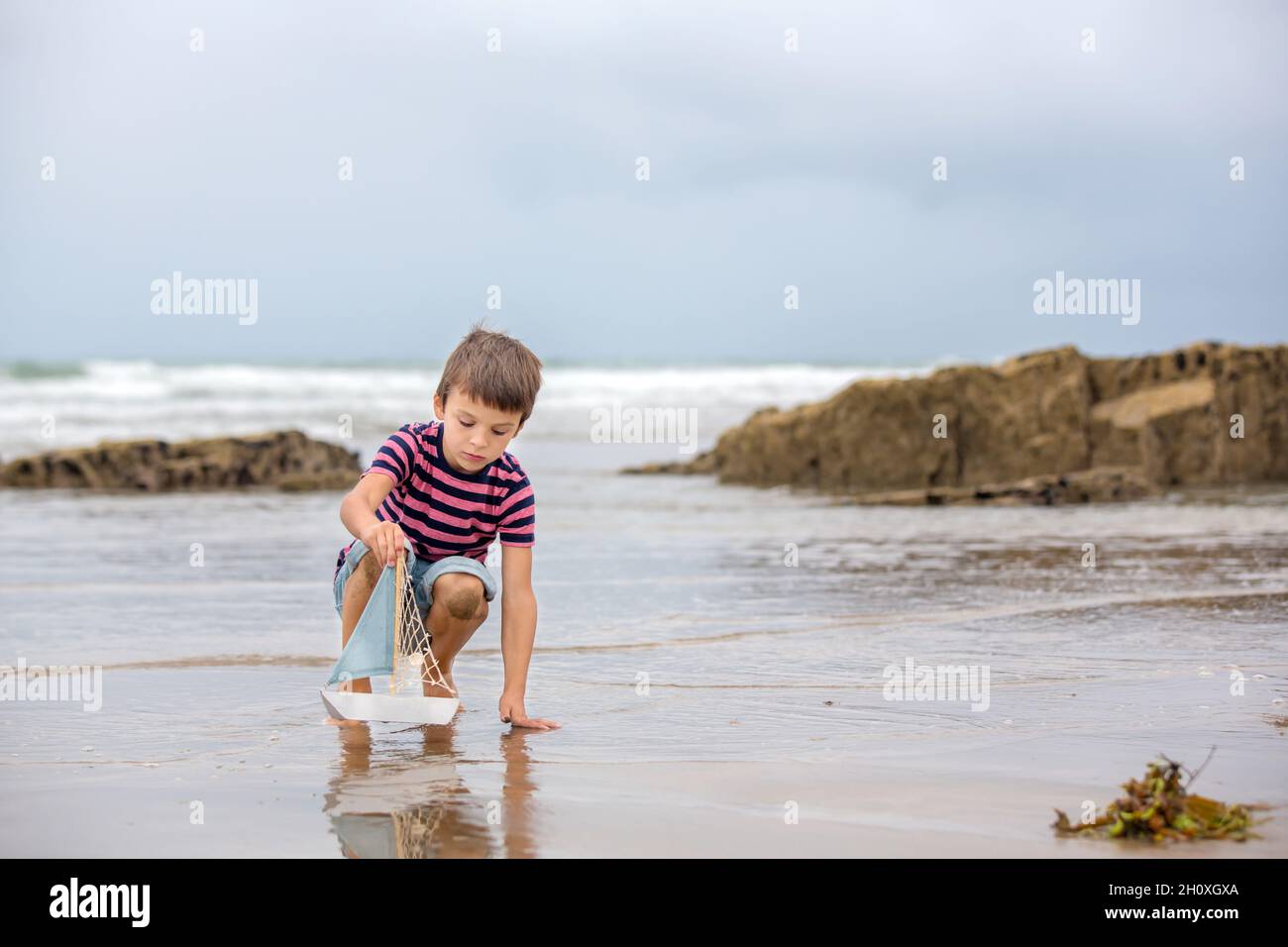 Kinder spielen mit Sand am Strand. Netter Vorschuljunge mit ...