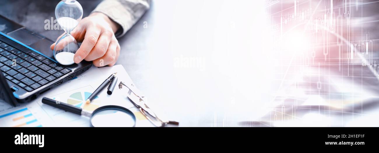 Arbeitszeit symbolisiert eine Sanduhr. Schreibtisch mit ...