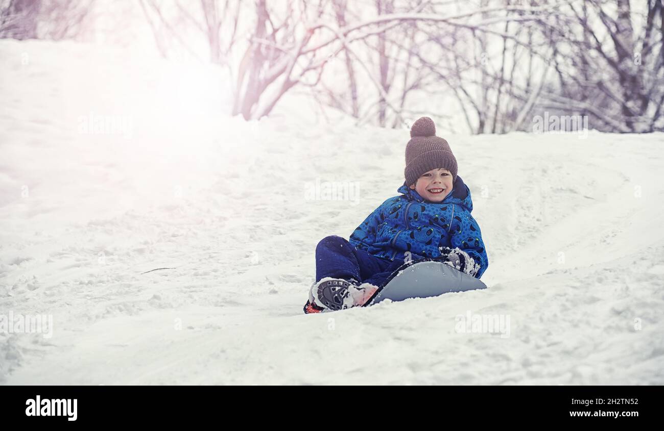 Kinder im Park im Winter. Kinder spielen mit Schnee auf dem Spielplatz ...