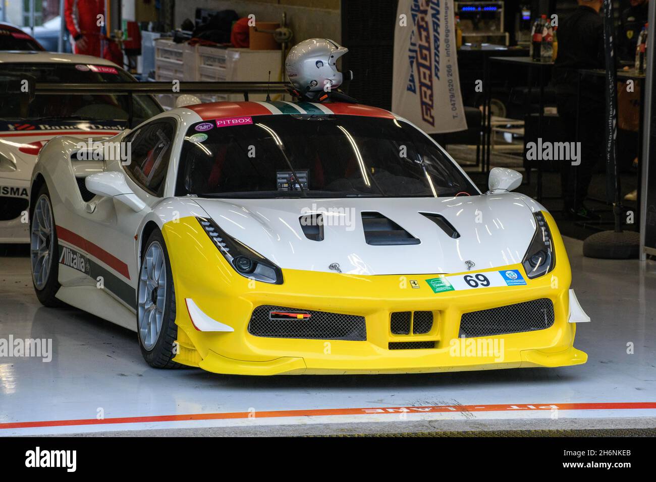 Ferrari 488 Challenge steht in der Boxenbox in der Boxengasse, davor ...