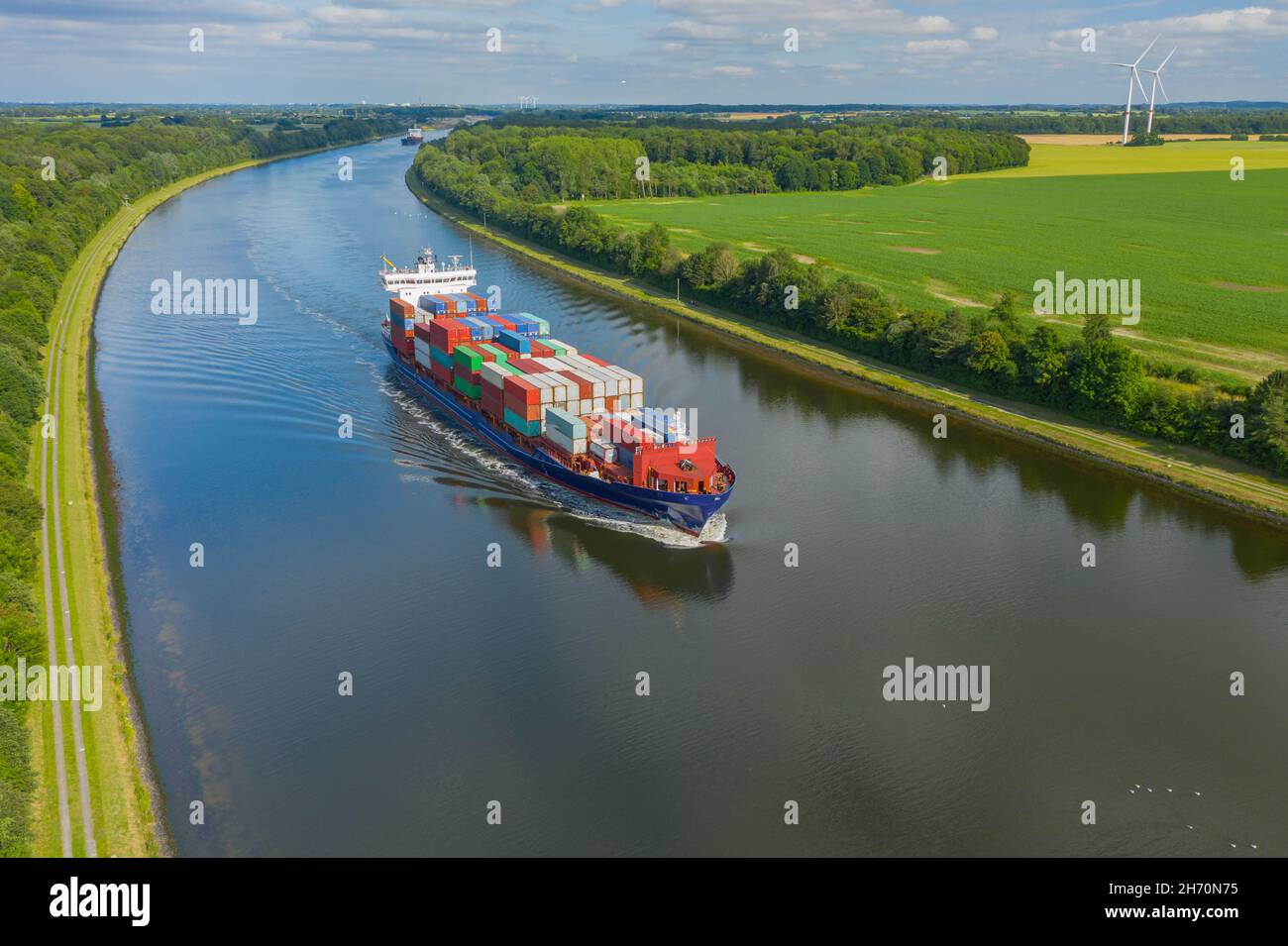 Containerschiffe auf dem Nord-Ostsee-Kanal und Windmühle im Hintergrund Stockfotografie - Alamy