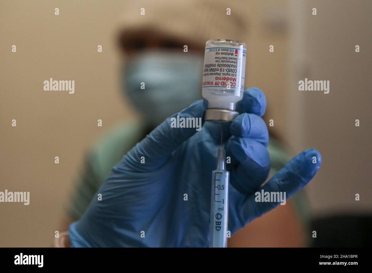 Ein NHS-Impfer bereitet sich darauf vor, eine Frau in einem Impfzentrum ...