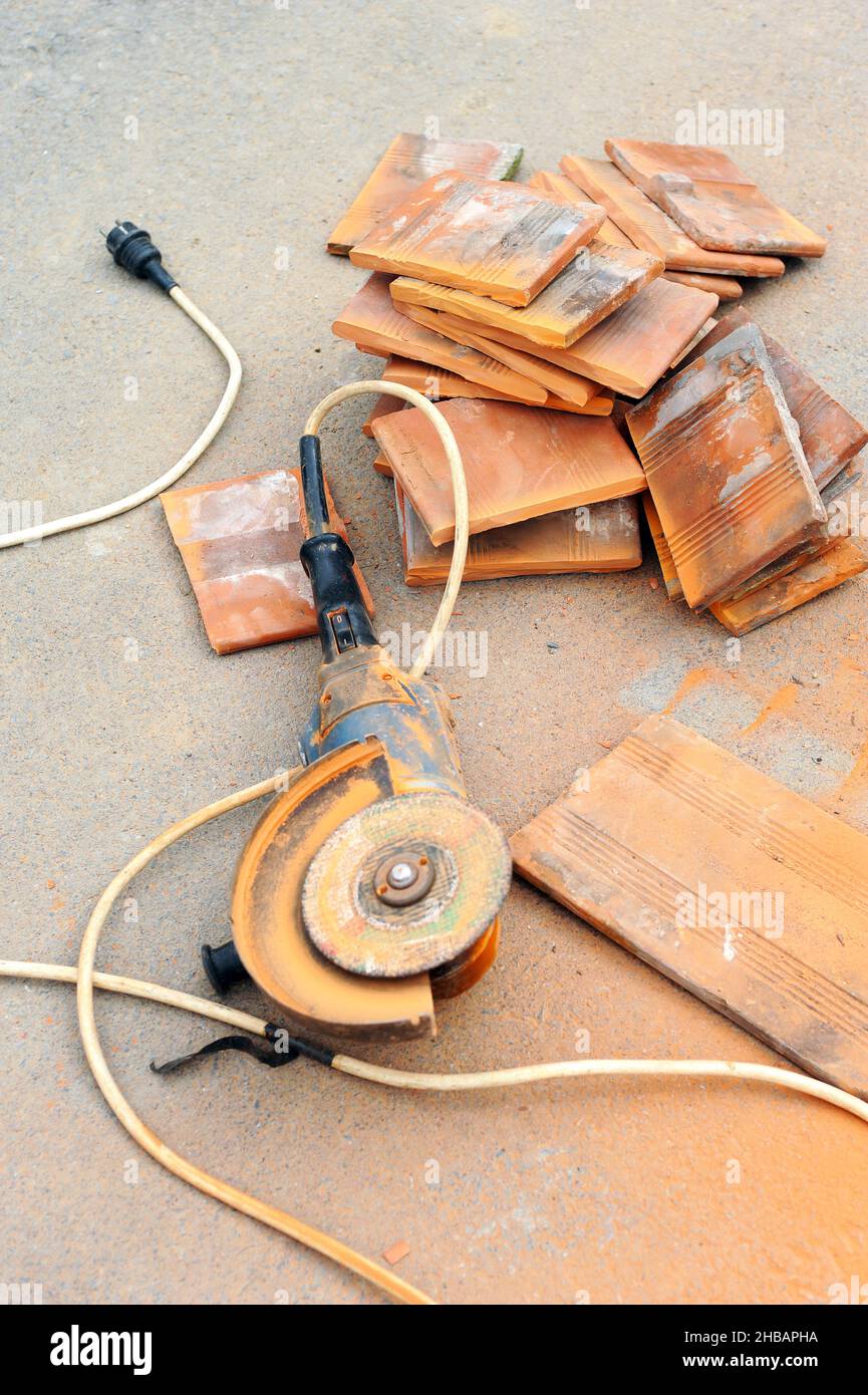 Der Schleifer schneidet die Fliese und ziegeln das elektrische Werkzeug ...