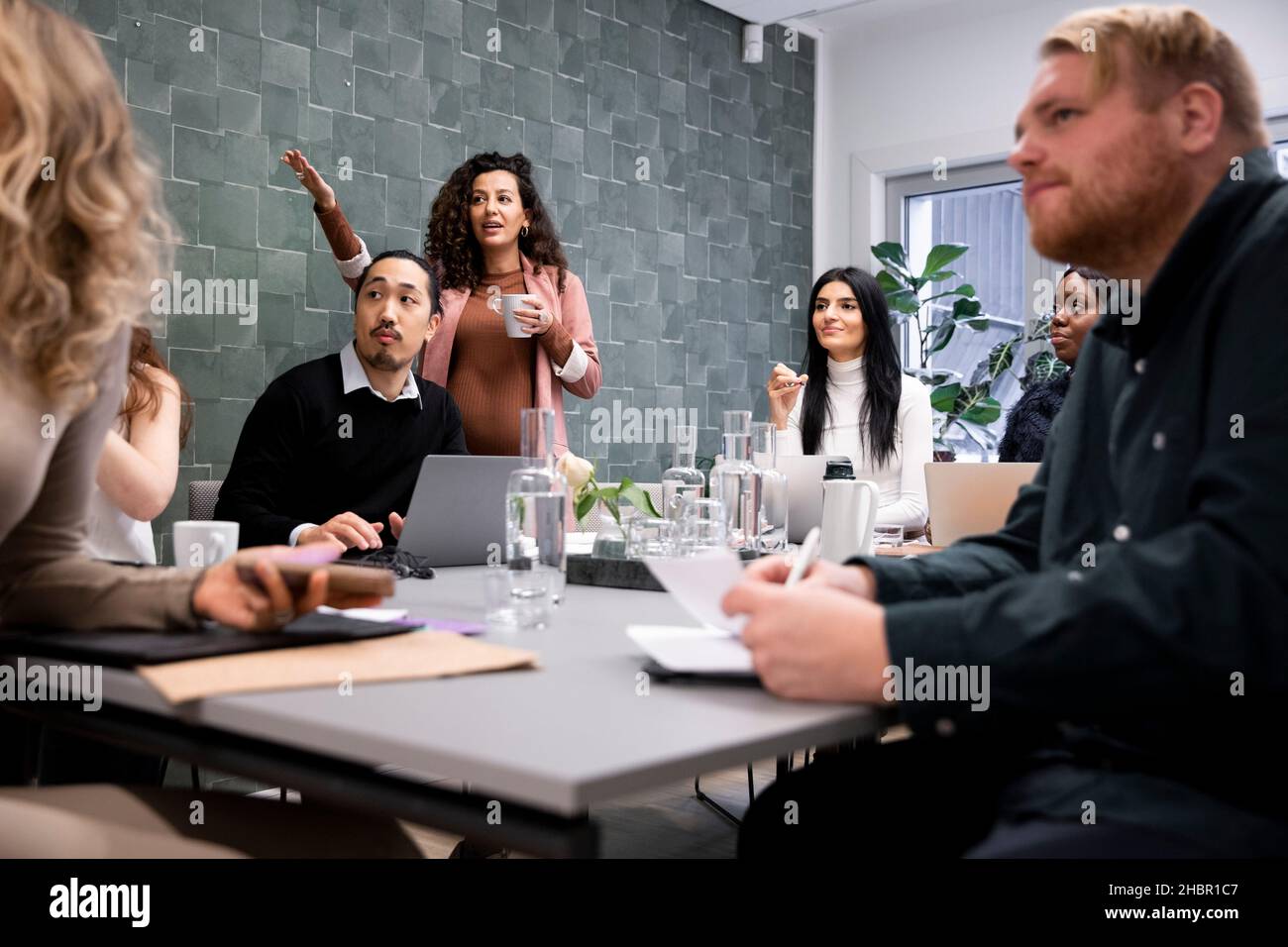 Die weibliche Vorgesetzte erklärt den Kollegen bei der Besprechung im ...
