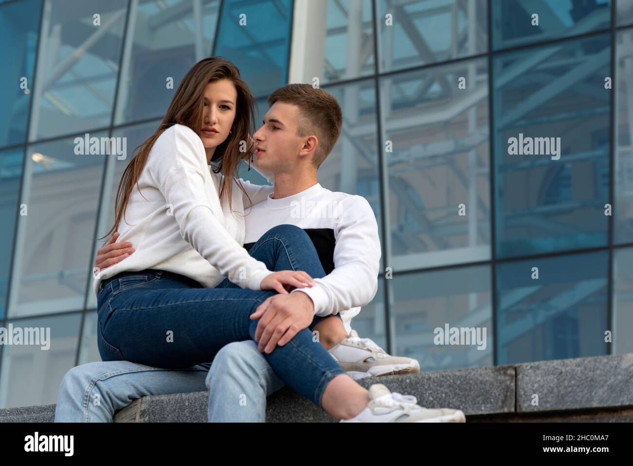 Stilvolles junges Paar auf dem Hintergrund der Glasfassade des Gebäudes ...