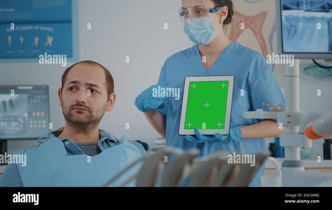 Stomatologie Krankenschwester vertikal hält Tablette mit grünem ...