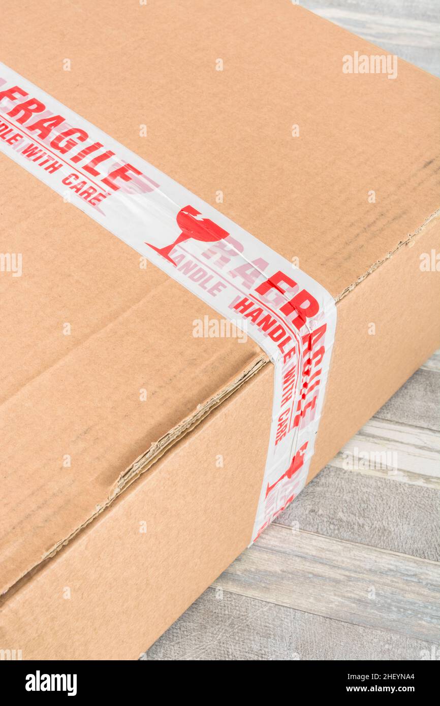 Versandkarton aus braunem Karton mit rot-weißem Haftklebeband aus ...