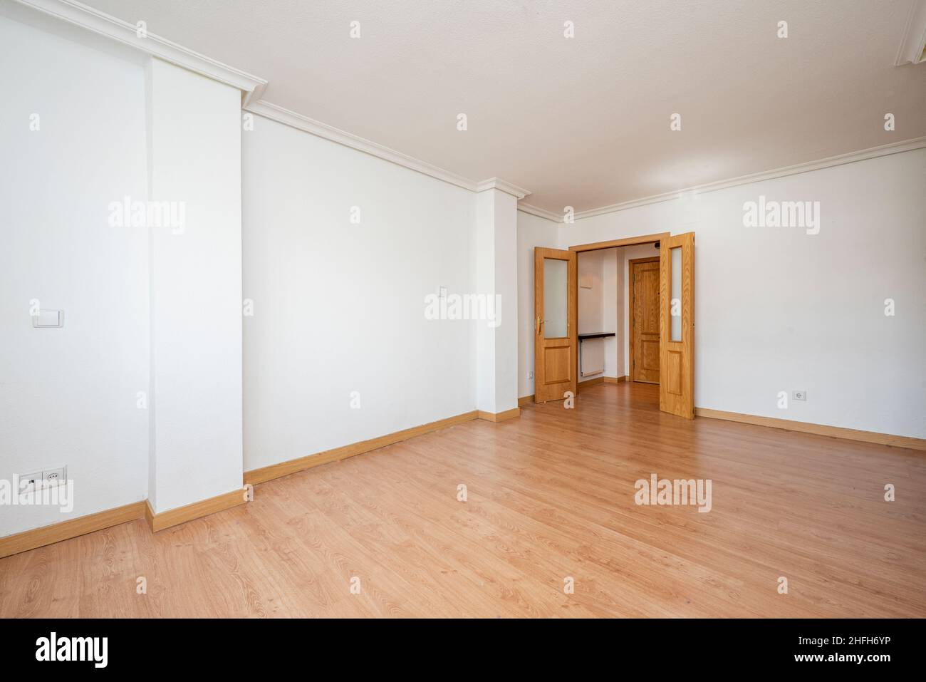 Großer leerer Raum mit hellen Eichenholzböden und Türen aus dem ...