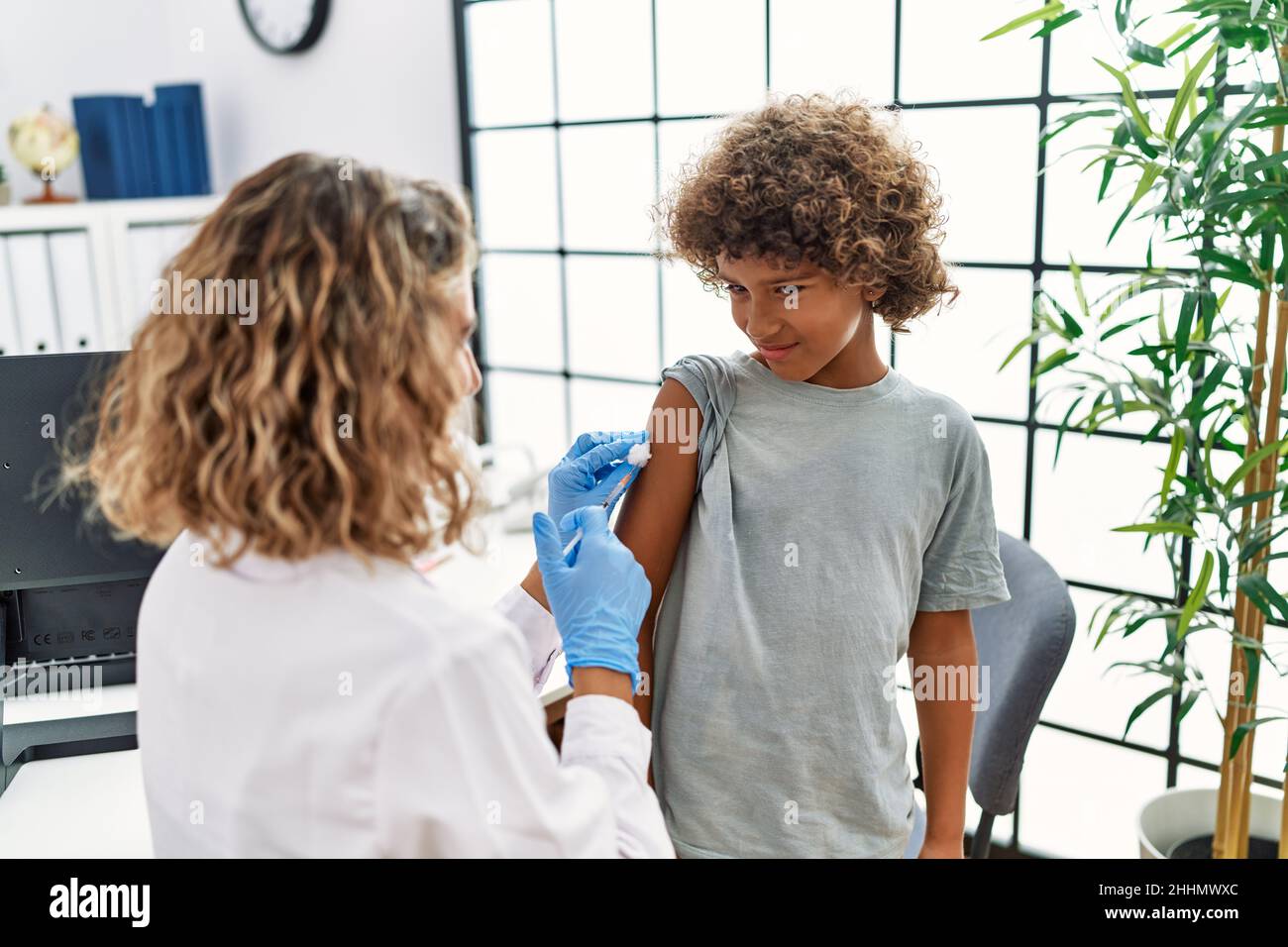 Mutter und Sohn tragen eine Arztzuniform, die das Kind in der Klinik ...