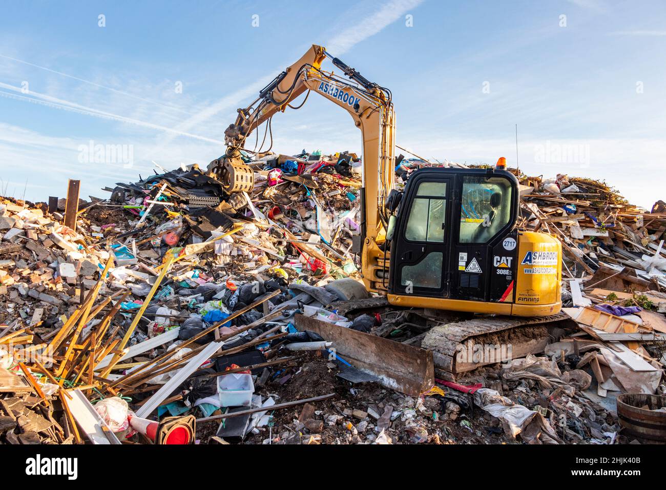 CAT- oder Raupenbagger, der auf einem Schrotthaufen auf einem ...