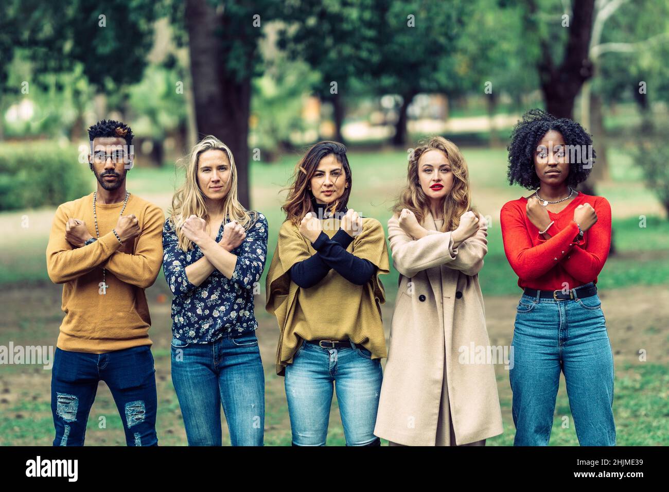 4 Frauen und ein Mann mit gekreuzten Armen und geballten Fäusten als ...