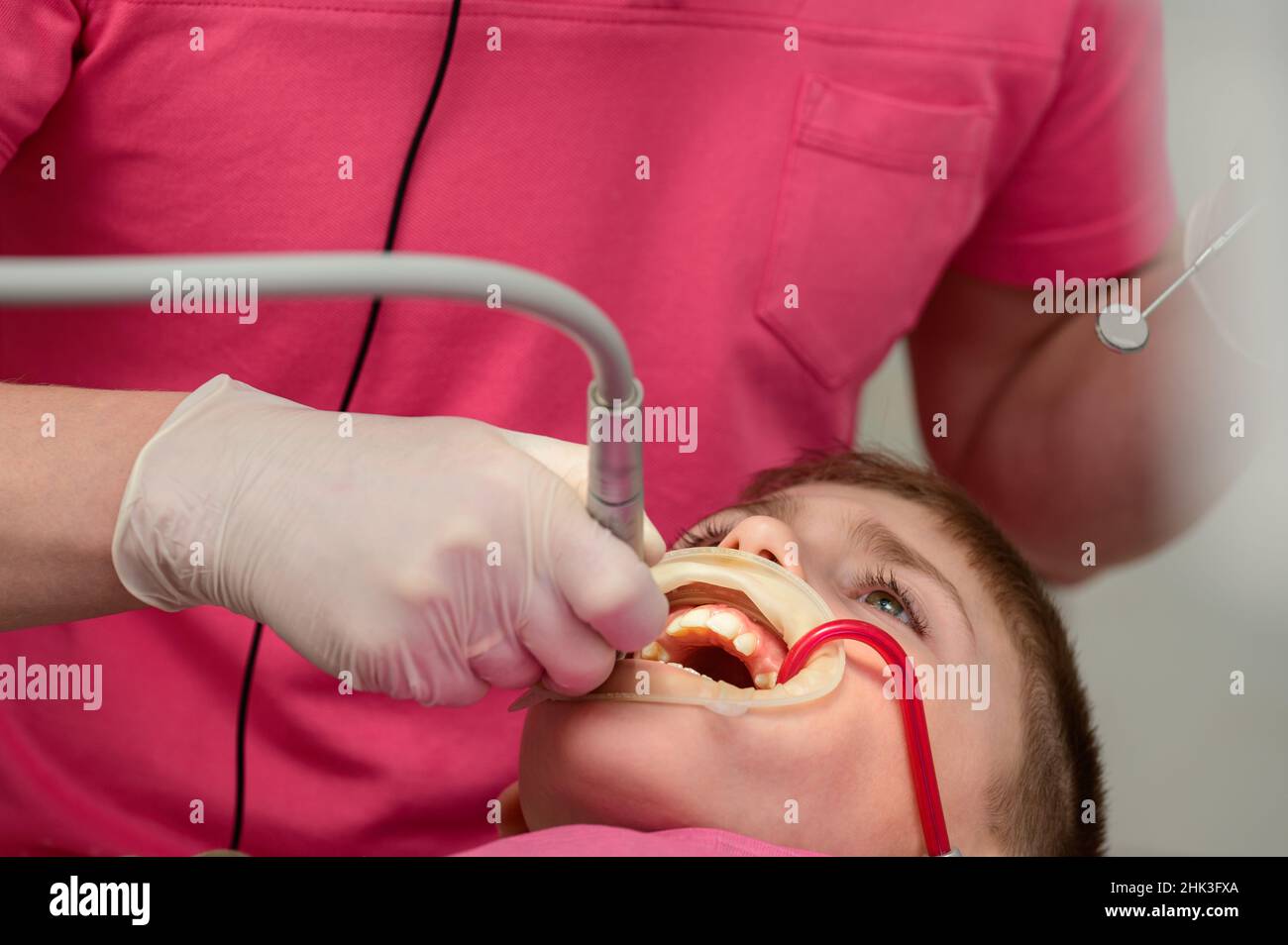 Der Junge sitzt auf einem Zahnarztstuhl und behandelt Karies bei einem ...
