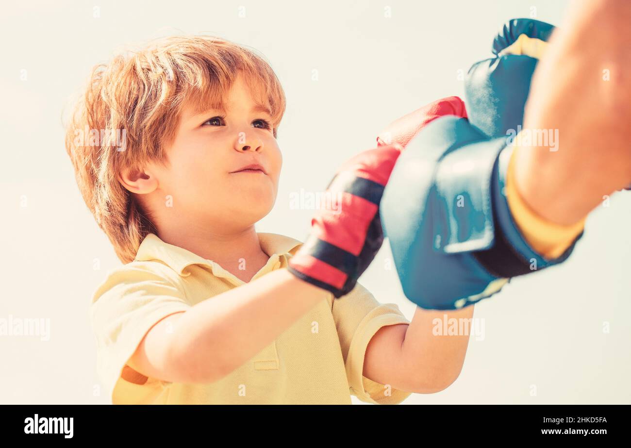 Vater trainiert seinen Sohn beim Boxen. Kleiner Junge tut Boxings Übung ...