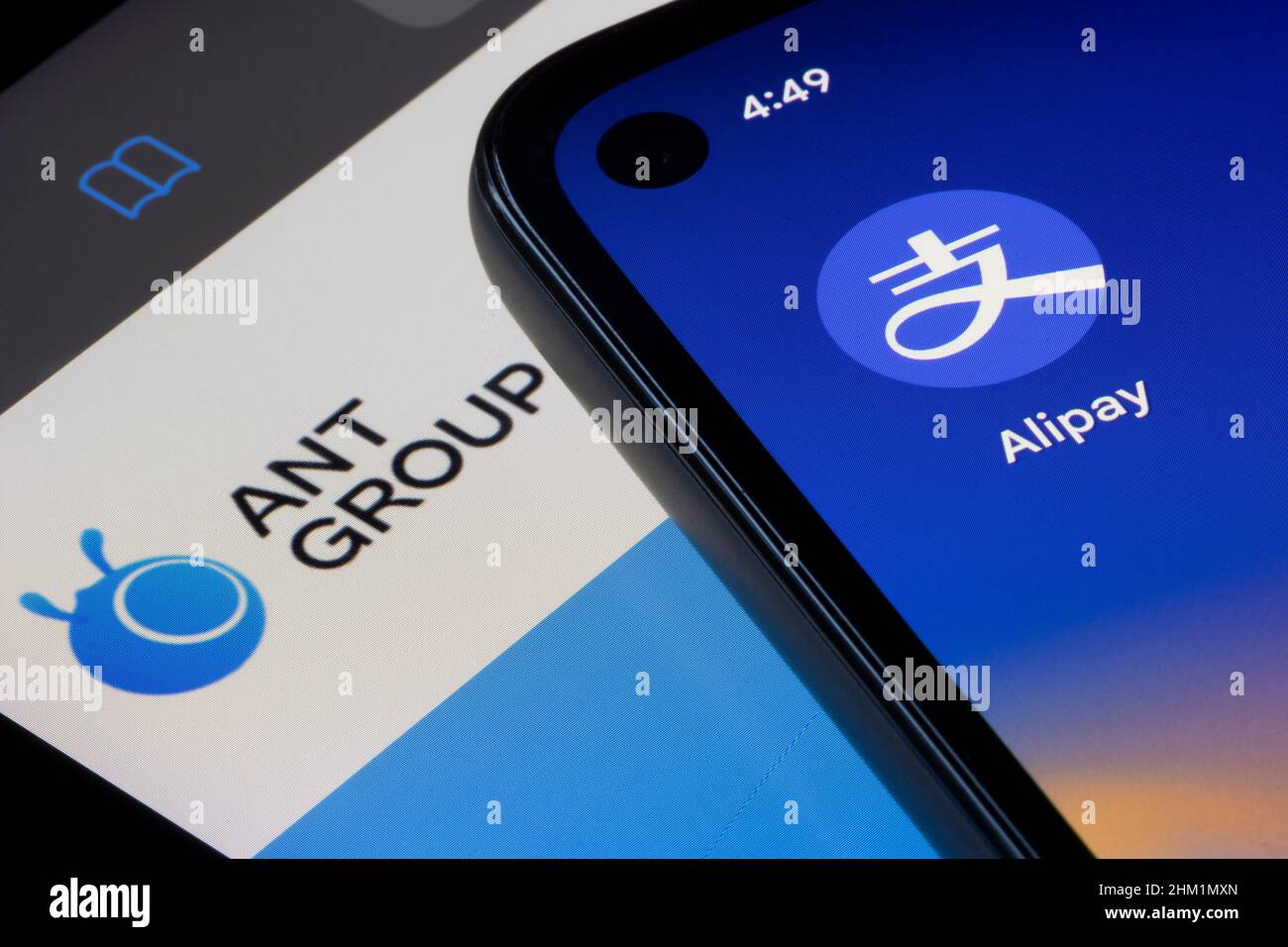 Das Alipay-App-Symbol wird auf einem Smartphone über einem iPad-Bildschirm angezeigt, auf dem ...