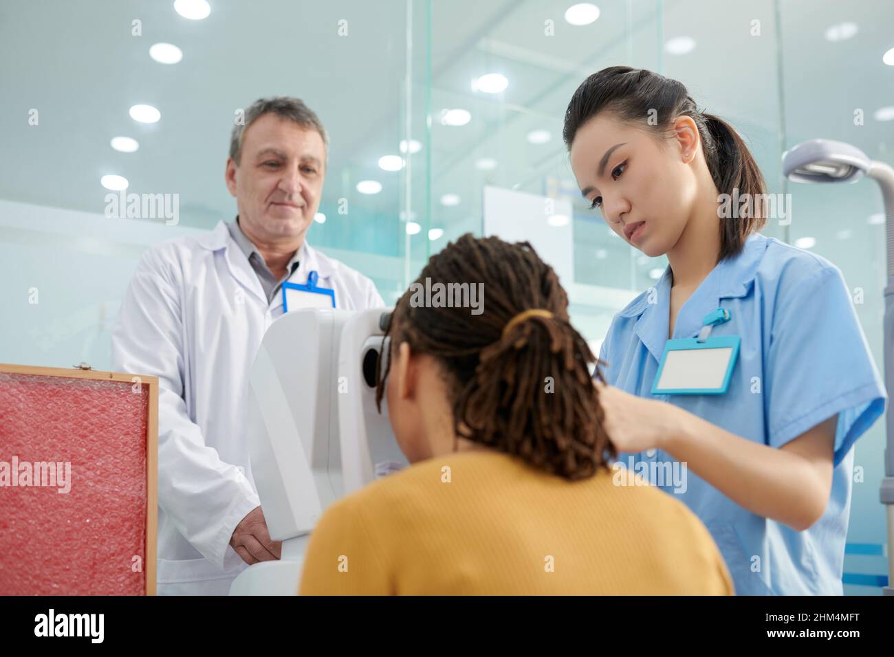Krankenschwester, die dem Patienten hilft, den Kopf in einen ...