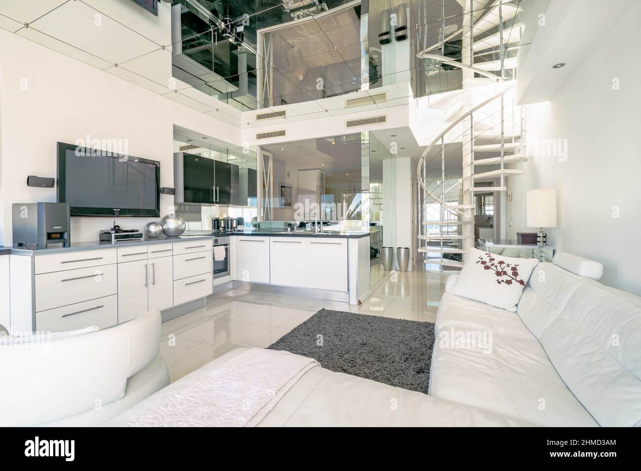 Ein Bild eines geräumigen Wohn- und Esszimmers mit einer Wendeltreppe ...