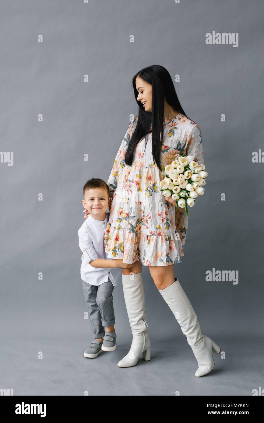 Porträt einer jungen Mutter mit einem Strauß weißer Tulpen und einem ...