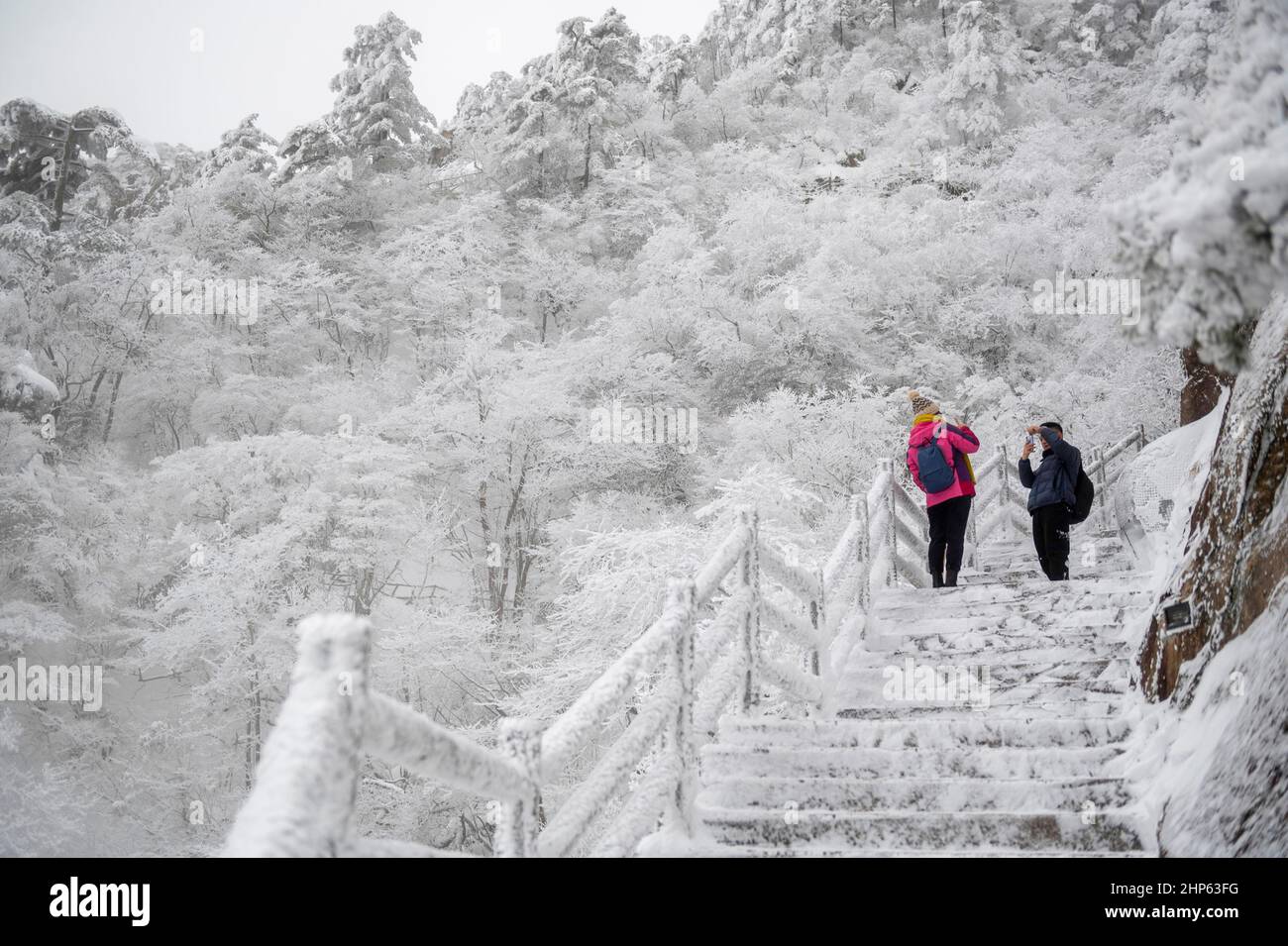 HUANGSHAN, CHINA - 18. FEBRUAR 2022 - Touristen fotografieren den Gelben Berg nach dem Schnee in ...