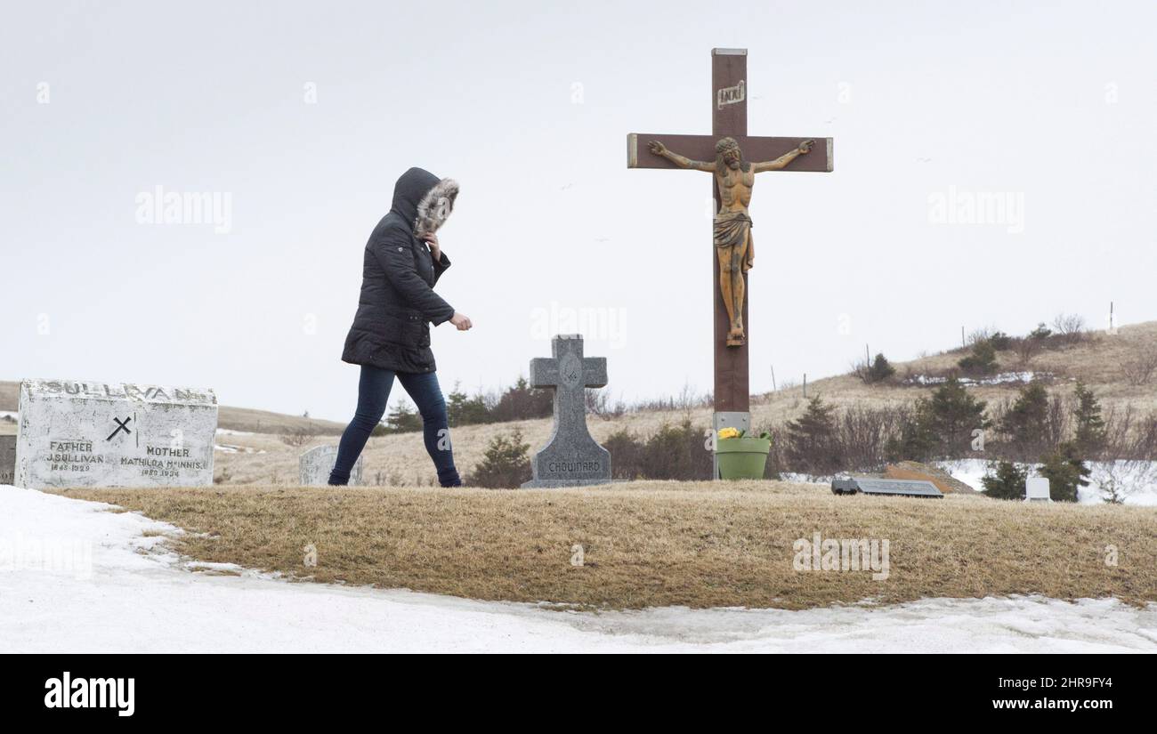 Eine Frau beschiligt sich vor starken Winden, als sie sich auf dem Weg ...